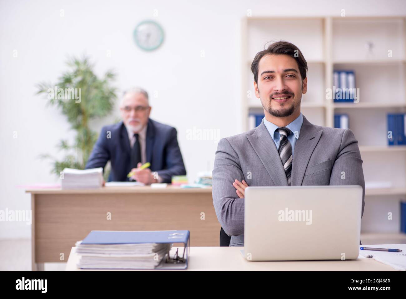 Two male employees working at workplace Stock Photo - Alamy