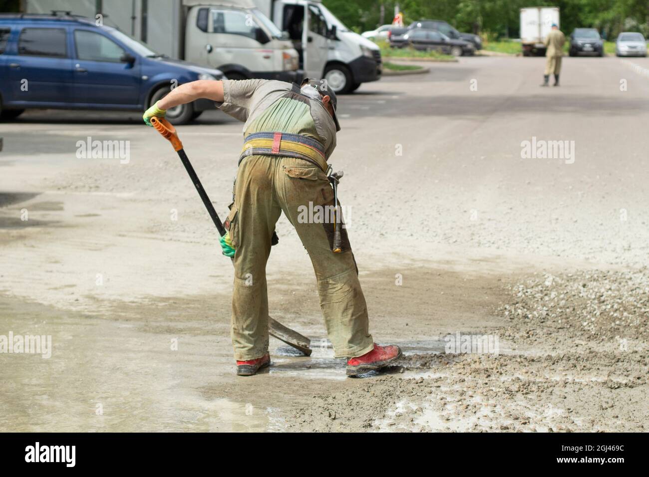 Work with a shovel at a construction site. A worker throws cement and ...