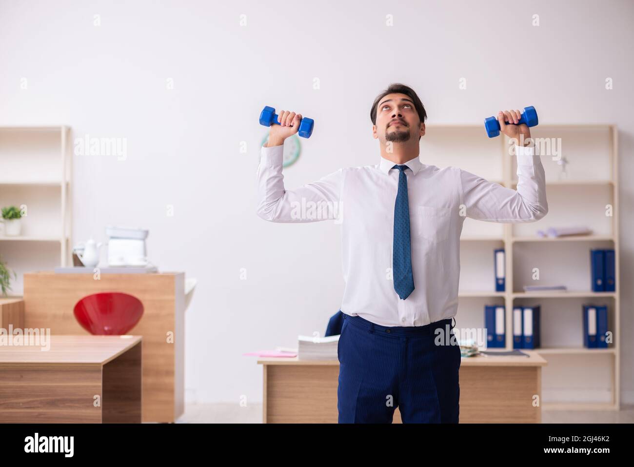 Young businessman employee doing sport exercises during break Stock ...