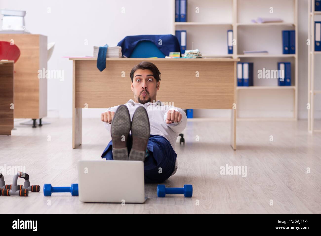 Young businessman employee doing sport exercises during break Stock ...