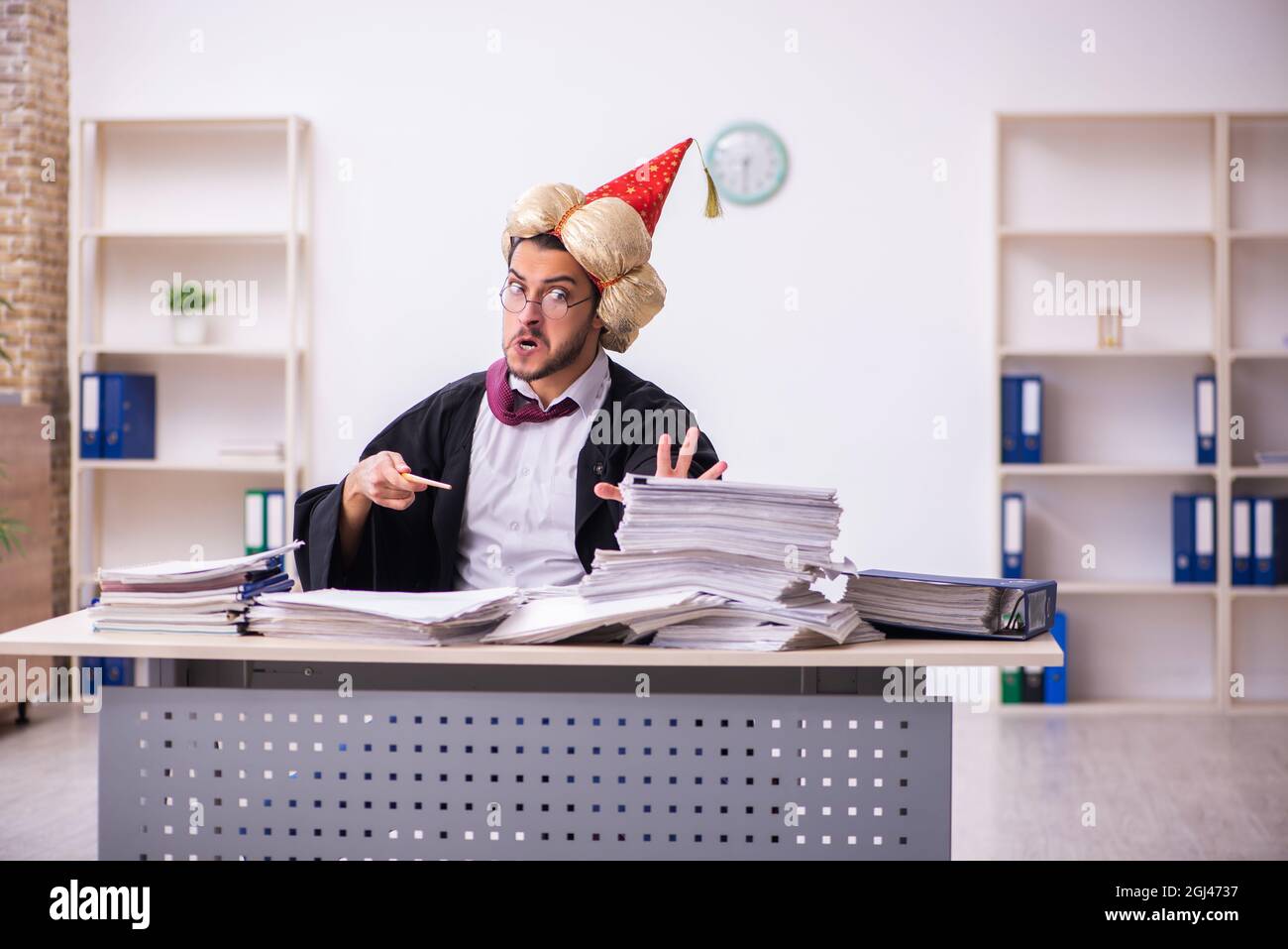 Funny young employee magician and too much work in the office Stock ...