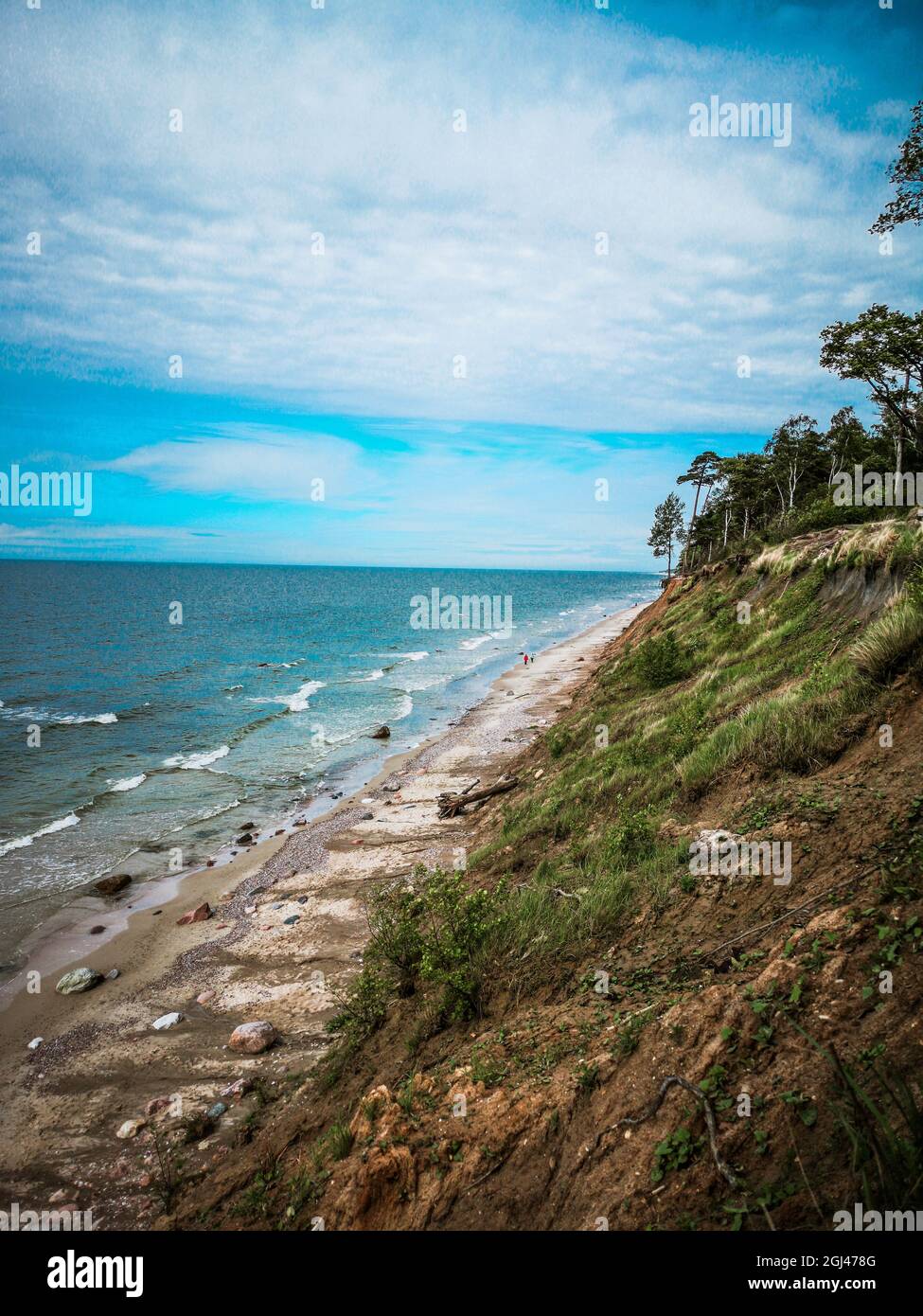 Aerial view of a beautiful beach with a wavy sea near the cliff under ...