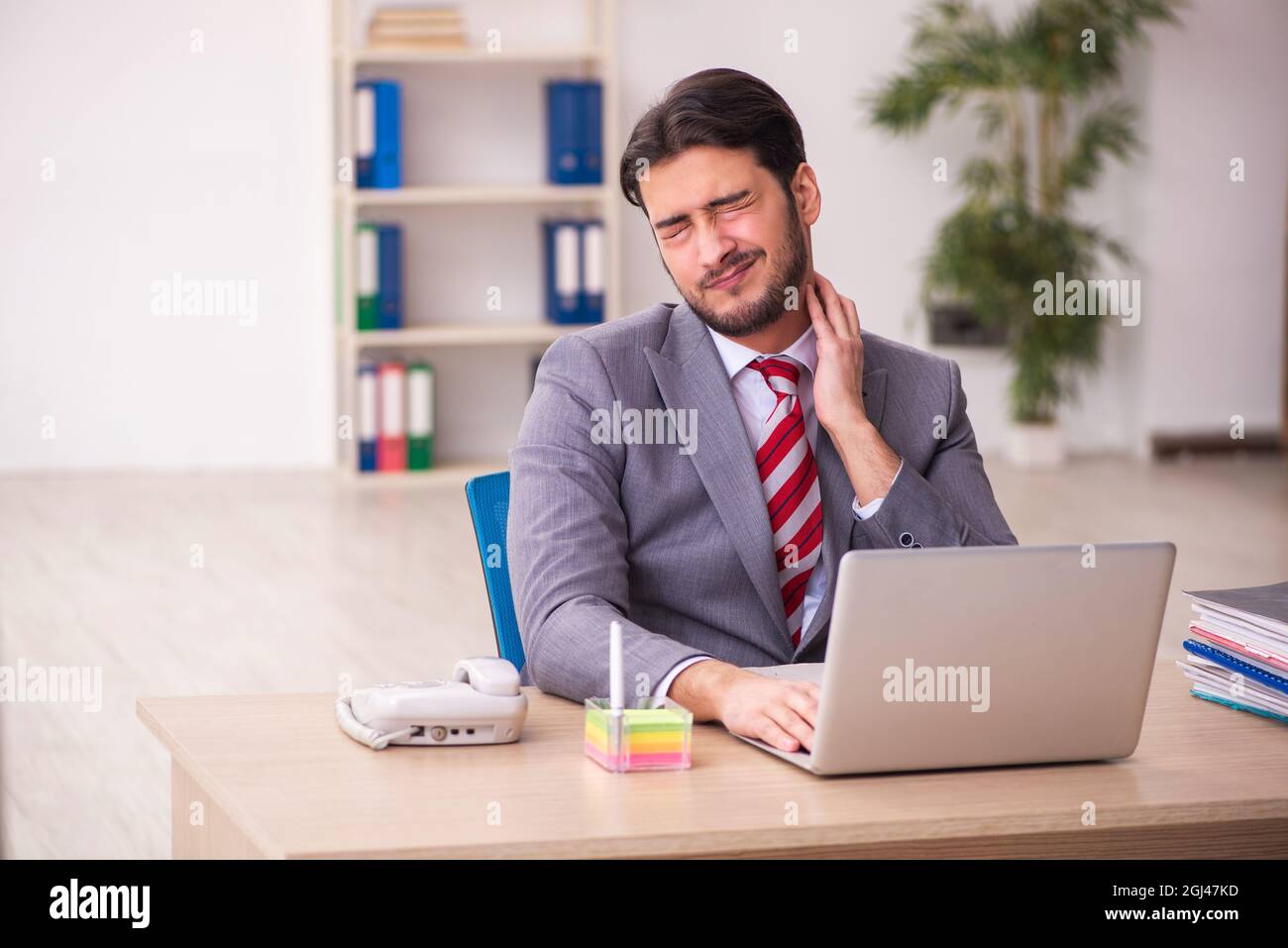 Young male employee working at workplace Stock Photo - Alamy