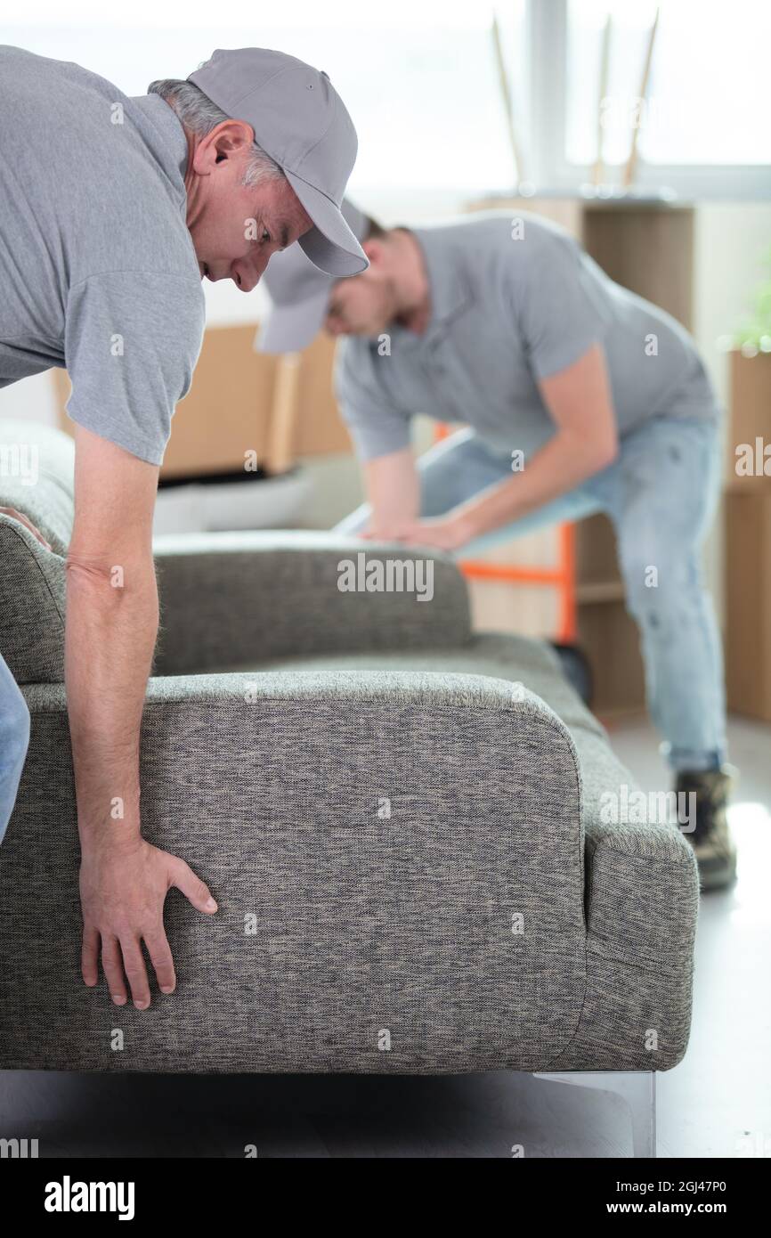 professional men moving a sofa into a property Stock Photo - Alamy