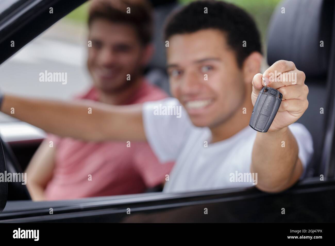 new young driver at the wheel showing key remote Stock Photo - Alamy