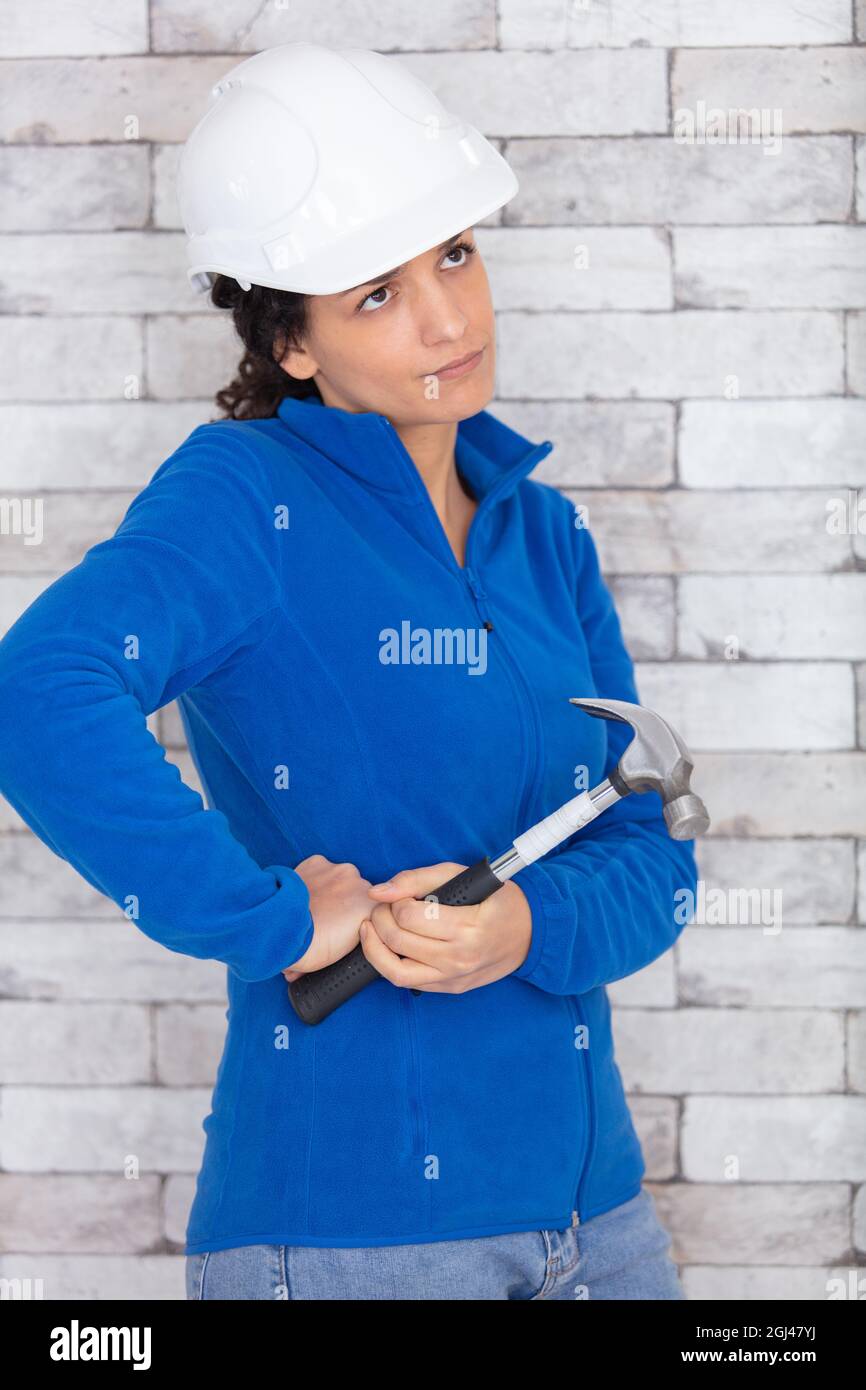pretty female worker holding hammer Stock Photo - Alamy