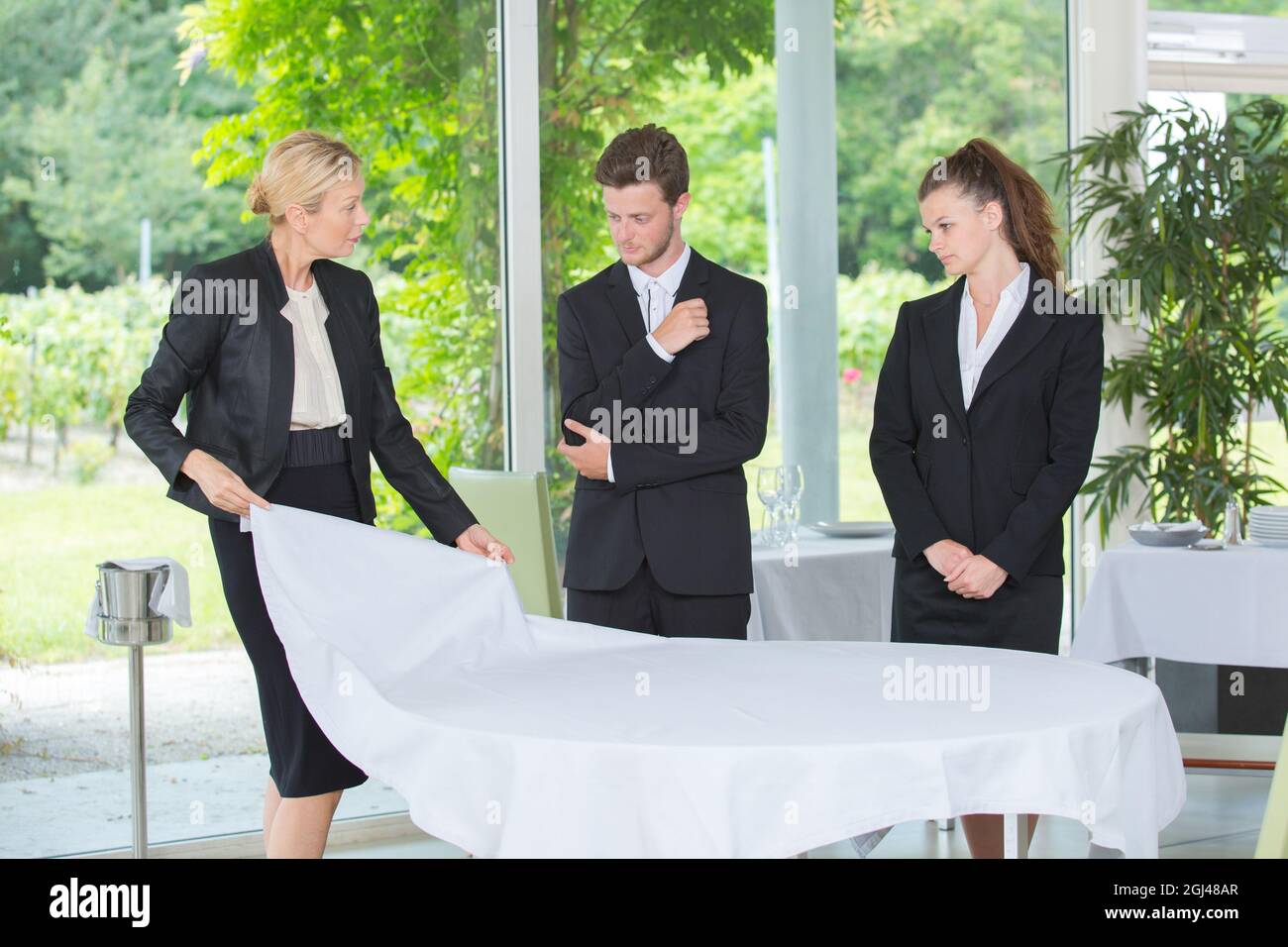 confident restaurant staff setting tables in gourmet restaurant Stock ...