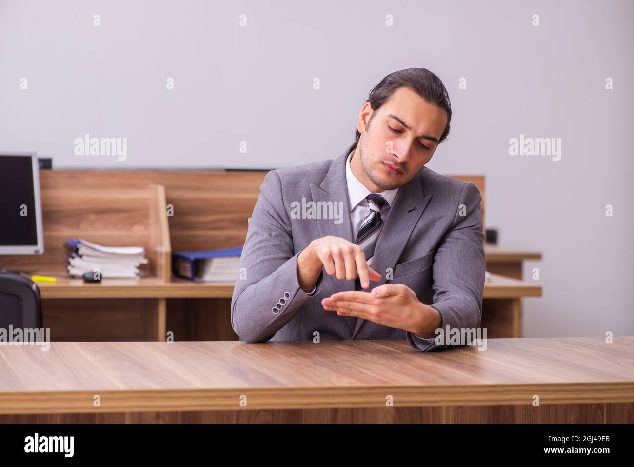 Young male employee working at workplace Stock Photo - Alamy