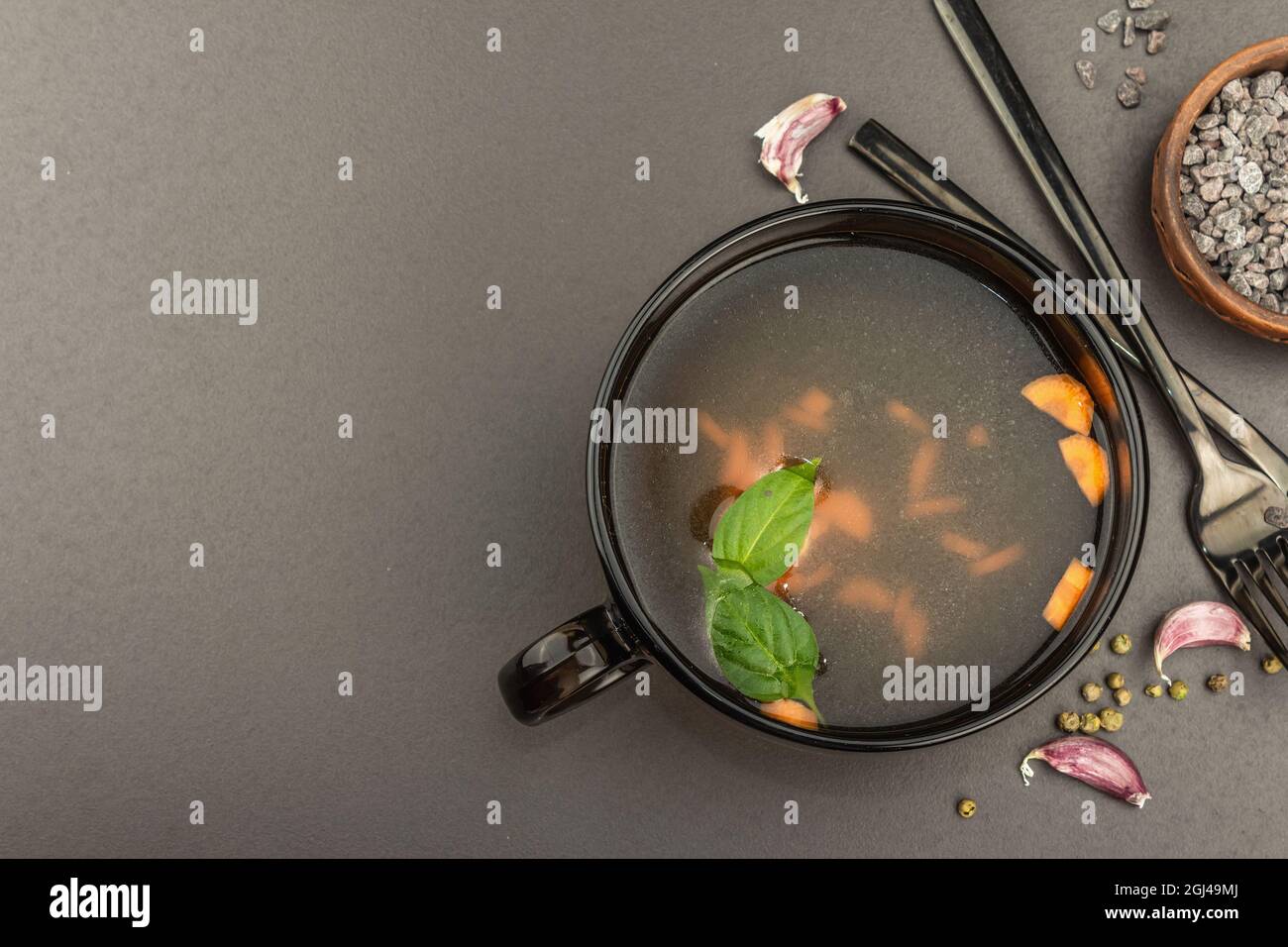 Transparent chicken broth with vegetables in a cup. Traditional ...