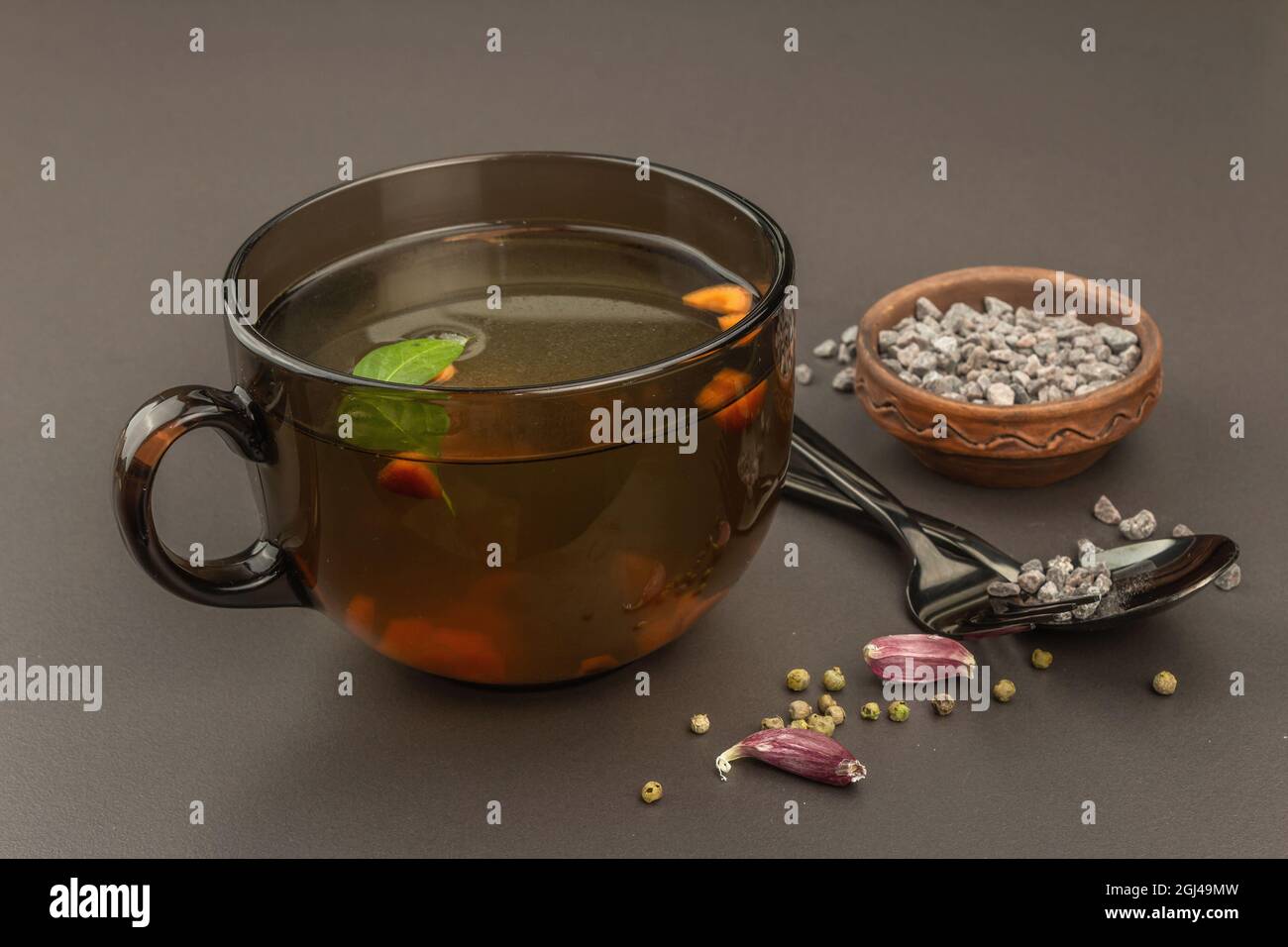 Transparent chicken broth with vegetables in a cup. Traditional ...
