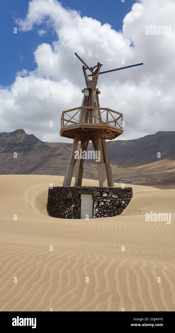 Vertical shot of a wooden tower in the sand on the beach with beautiful ...