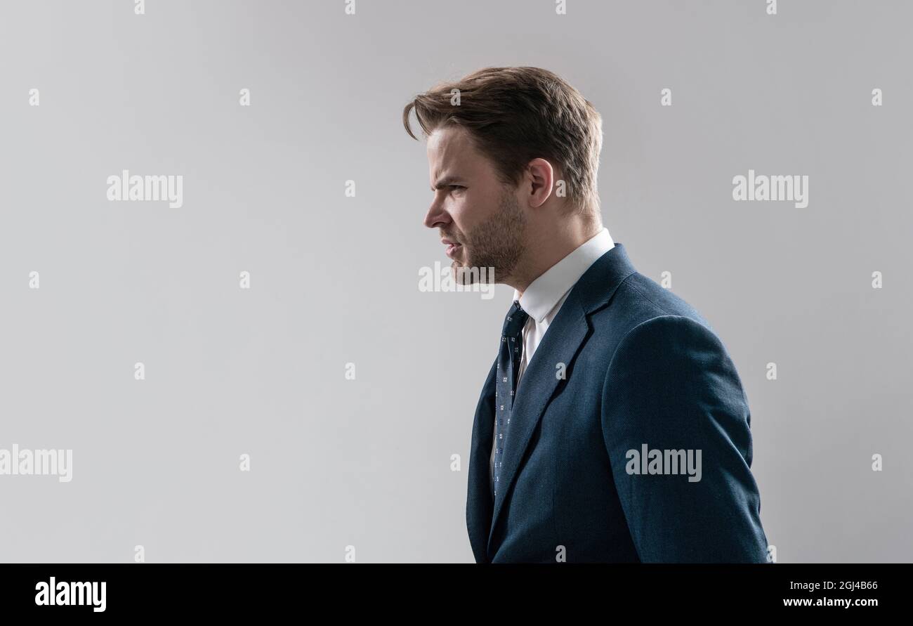Angry business professional man stand sideway in anger grey background ...