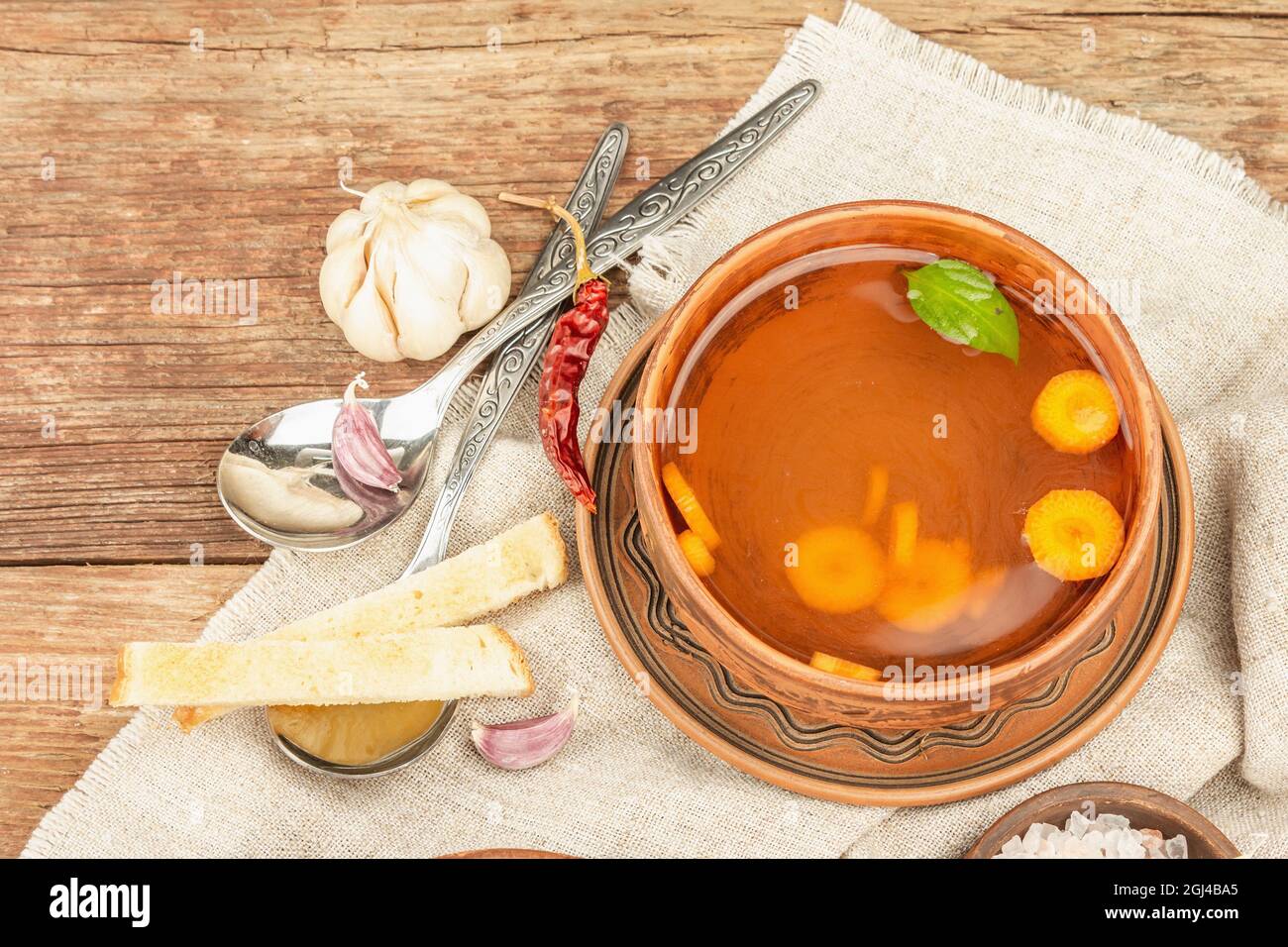 Transparent chicken broth with vegetables in ceramic bowls. Traditional ...