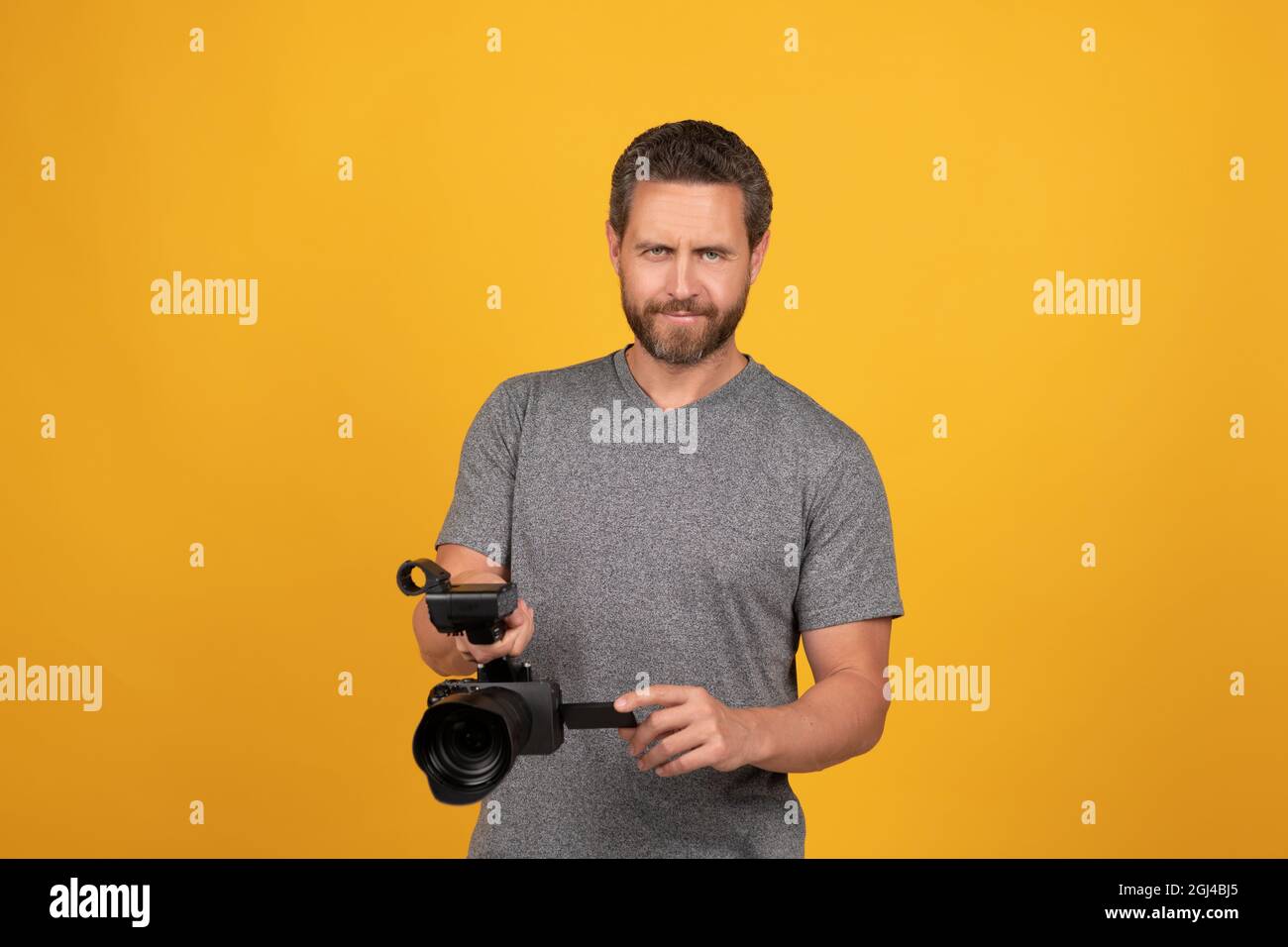 smiling cameraman vlogging with film set. unshaven man with camcorder ...