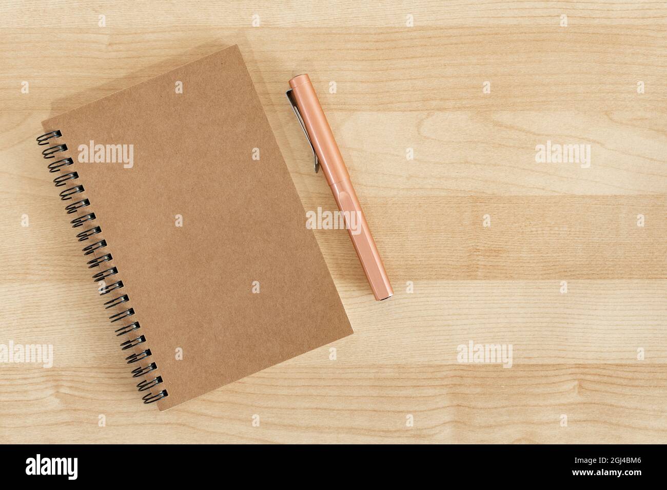 Eco-friendly carton recycled notebook with a pen on a wooden office ...