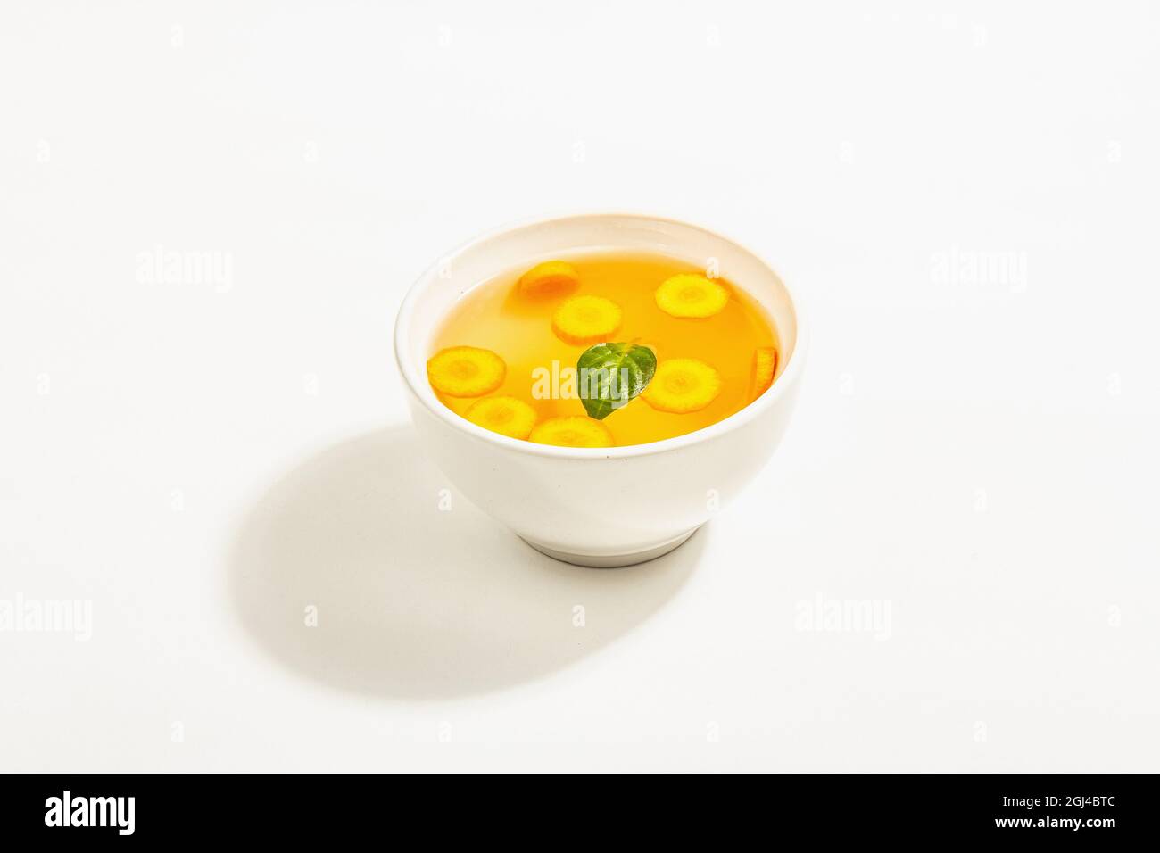 Transparent chicken broth in a ceramic bowl isolated on white ...
