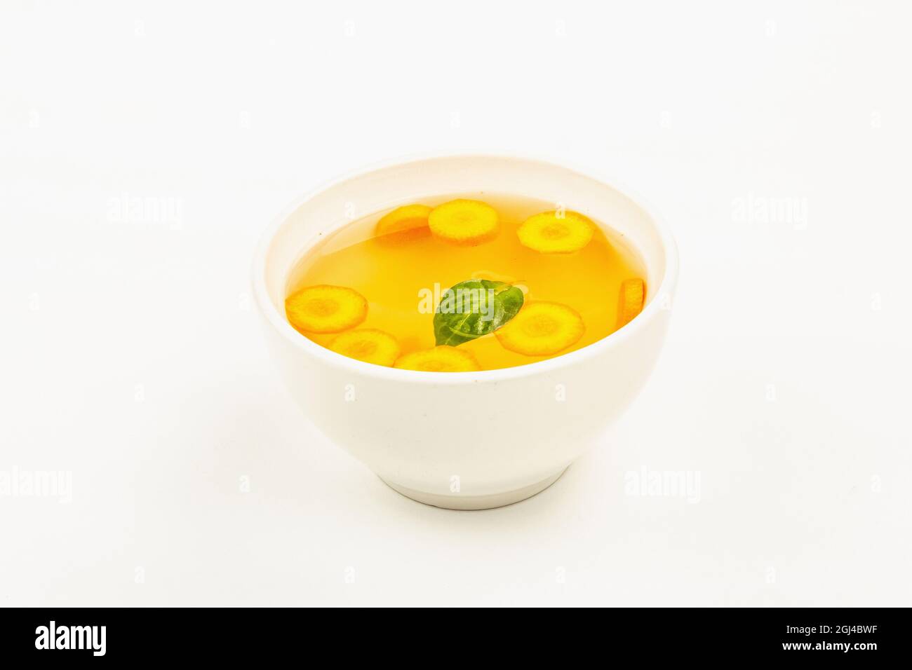 Transparent chicken broth in a ceramic bowl isolated on white ...