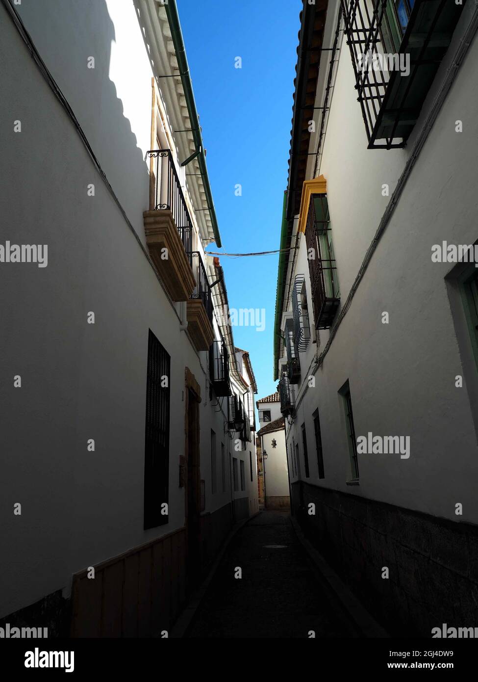 Vertical shot of an alley through white old buildings Stock Photo - Alamy