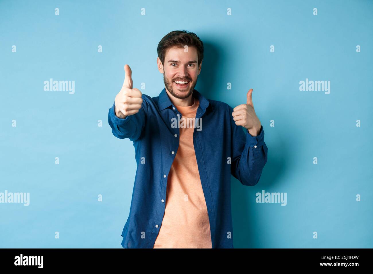 Positive smiling guy showing thumbs up and smiling, complimenting you ...