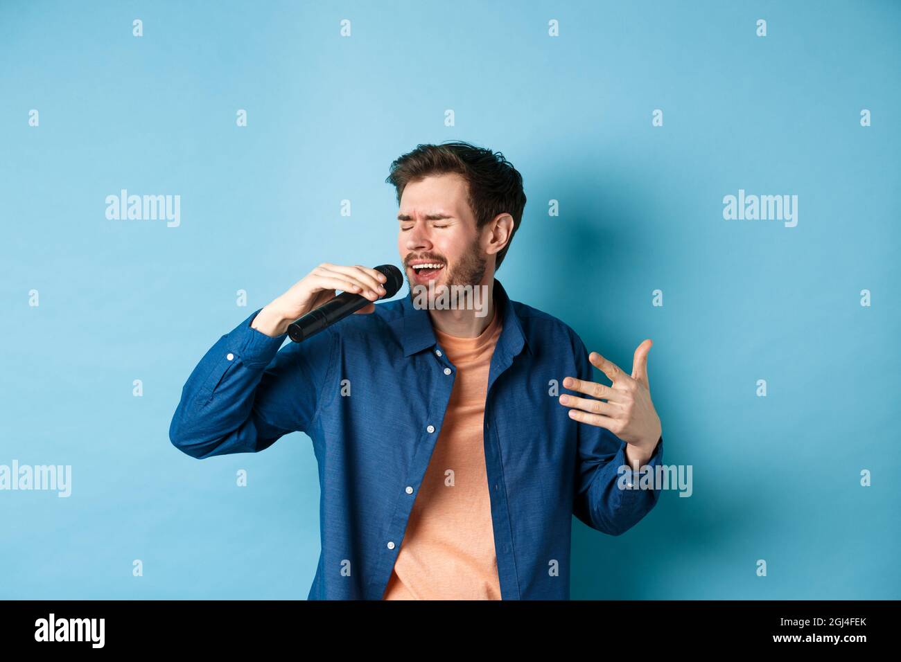 Romantic guy singing song in microphone and gesture, singer playing ...