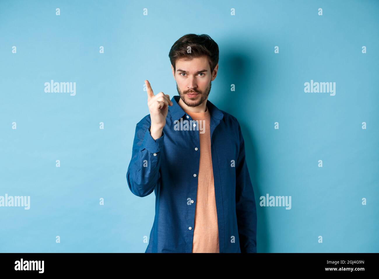 Serious young man scolding person, shaking finger disapprovingly, warn ...