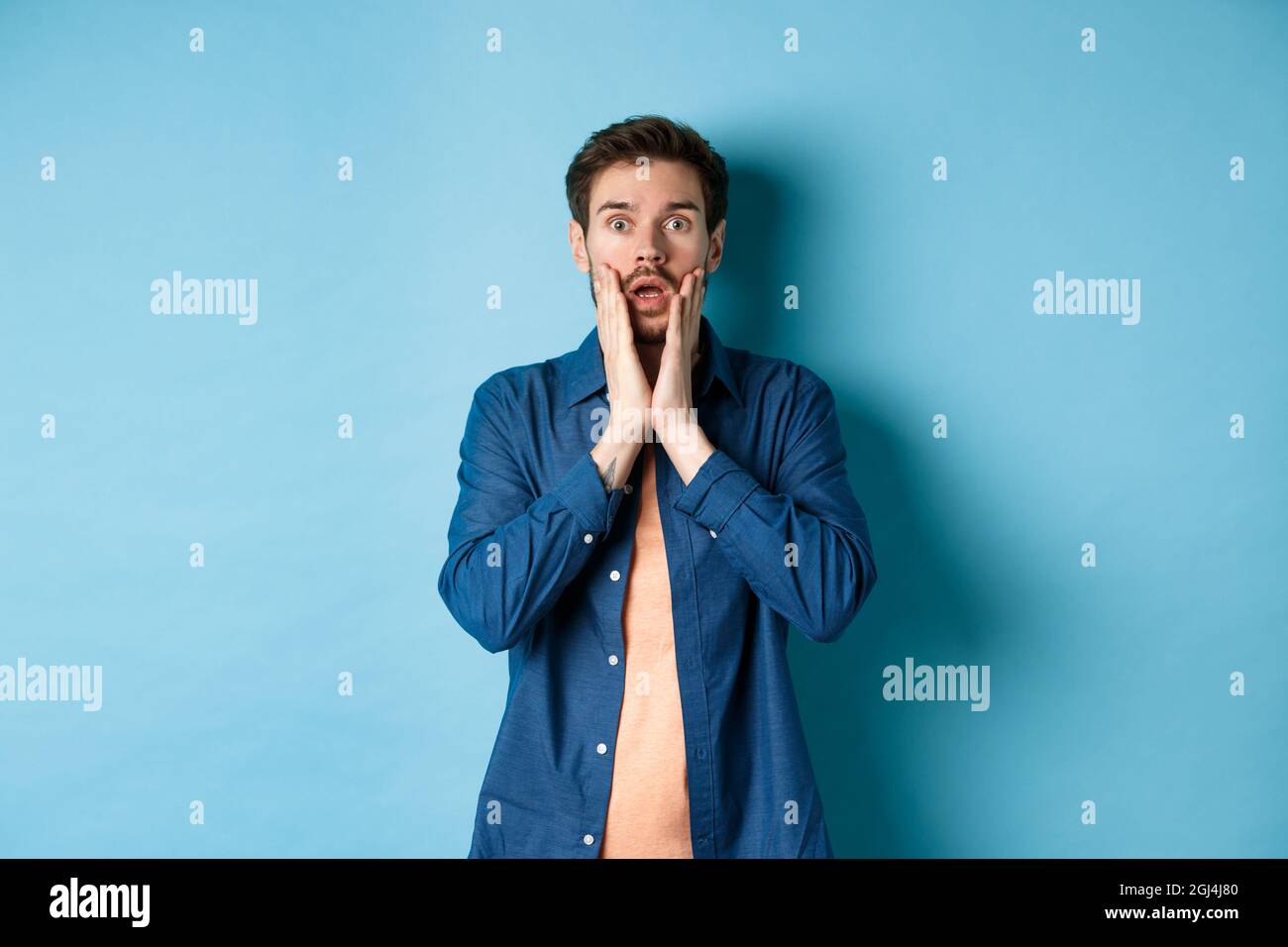 Portrait of guy gasping and dropping jaw with shocked face, staring at ...