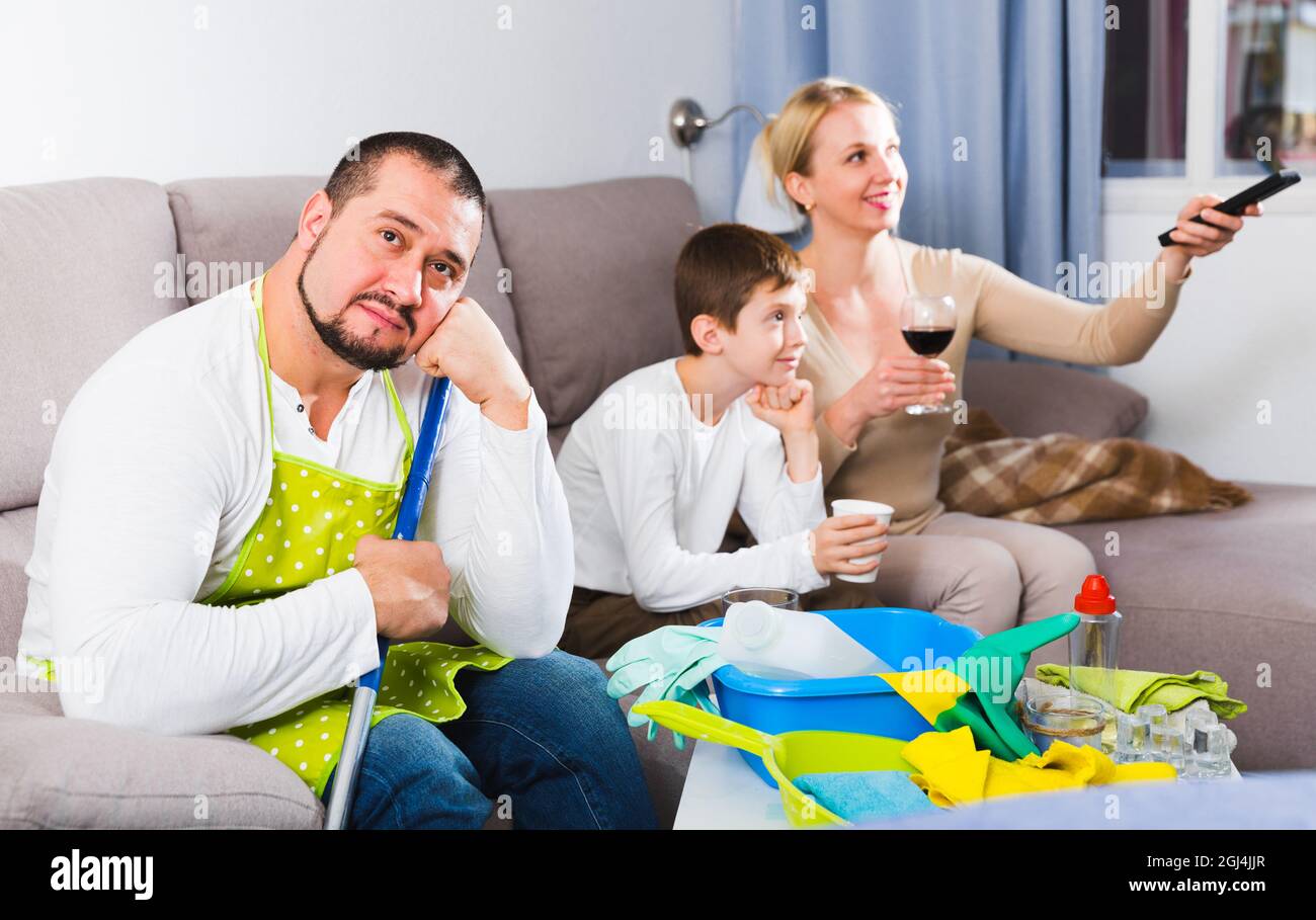 Tired father with cleaning equipment Stock Photo - Alamy