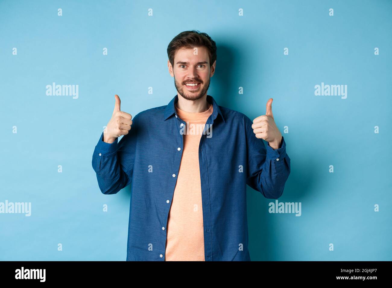 Handsome smiling man being supportive, showing thumbs up in approval ...