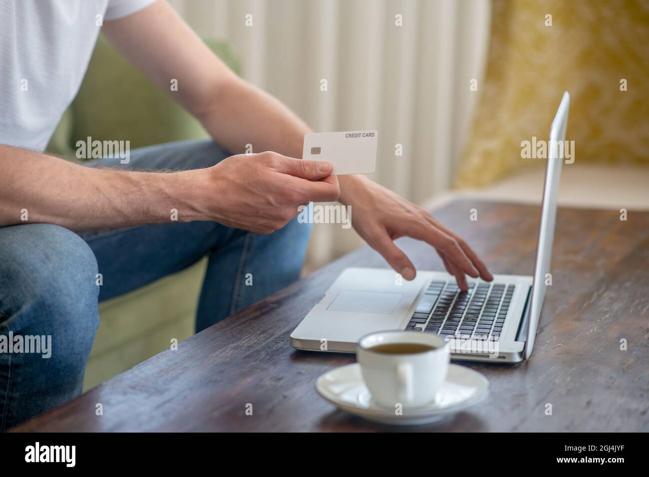 A man sitting at the laptop and paying by credit card online Stock ...