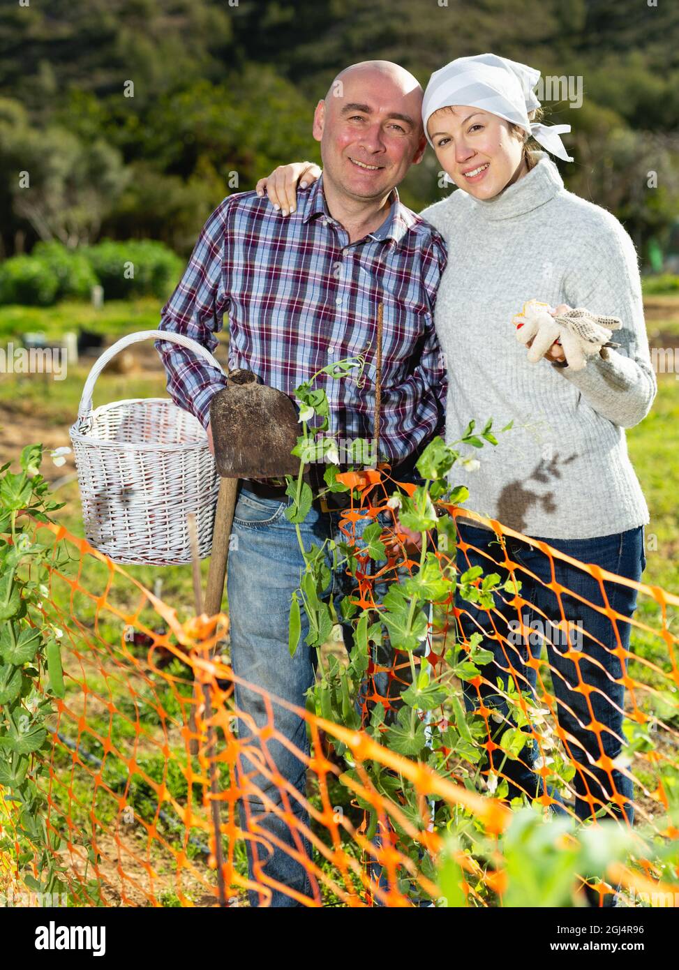 Happy couple with garden tools in garden Stock Photo - Alamy