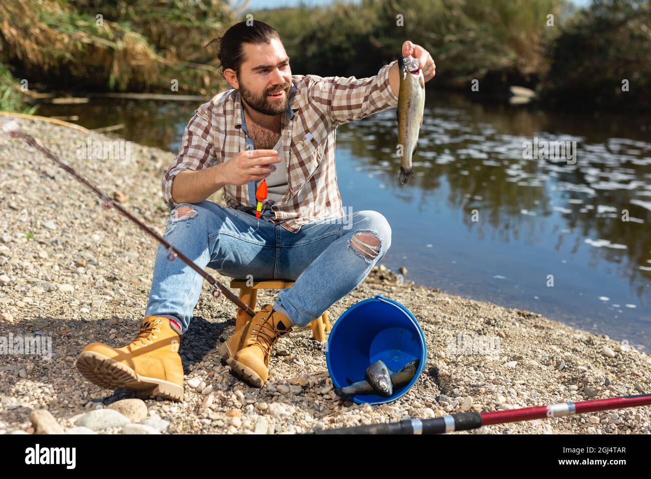 Adult male fisherman holding fish in his hands Stock Photo - Alamy