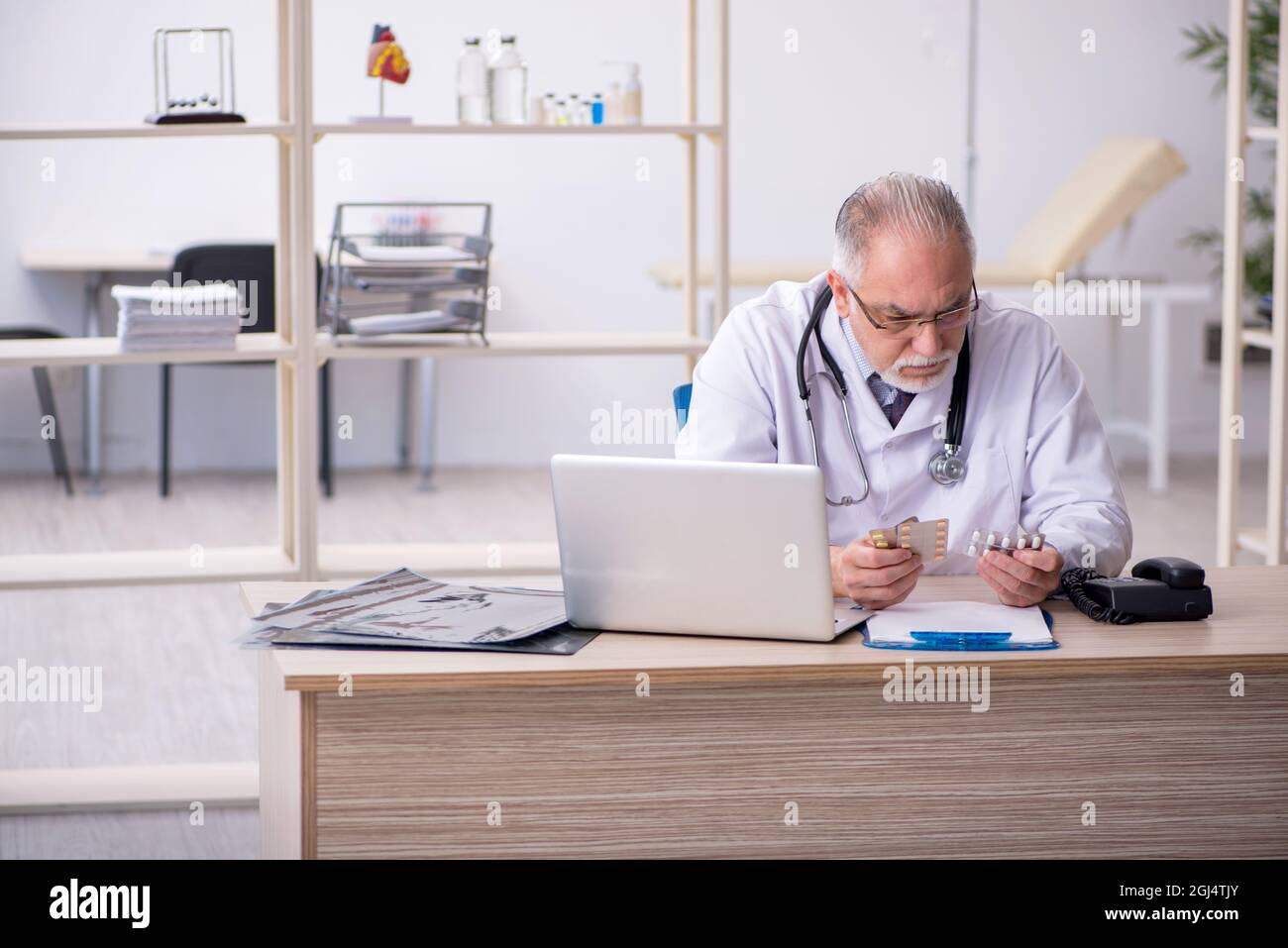Old male doctor working at the hospital Stock Photo - Alamy