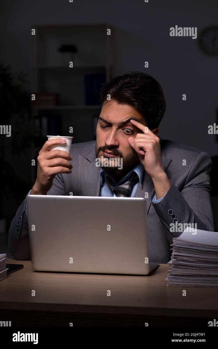 Young employee working late in the office Stock Photo - Alamy