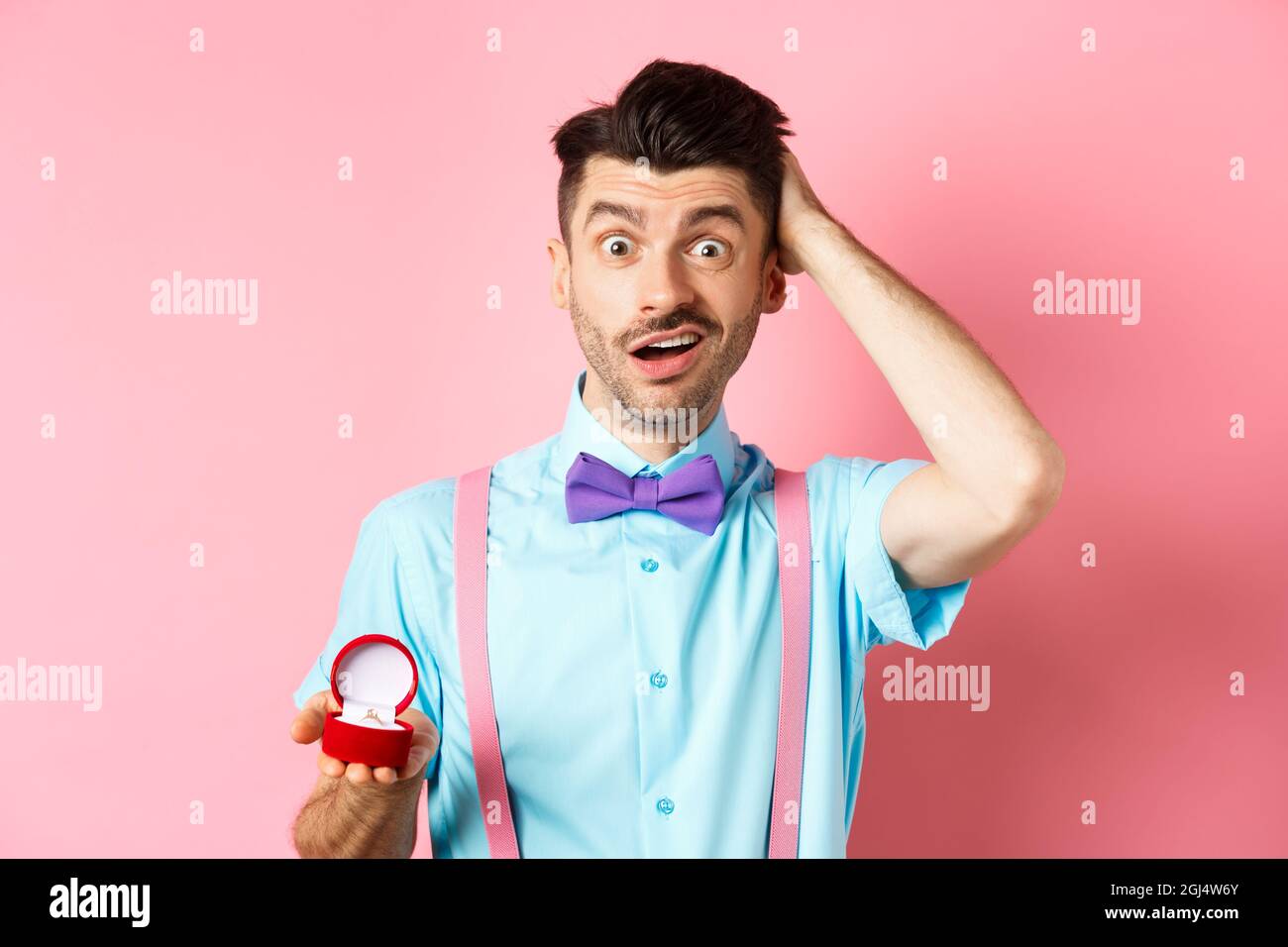 Valentines day. Confused funny guy standing with engagement ring ...