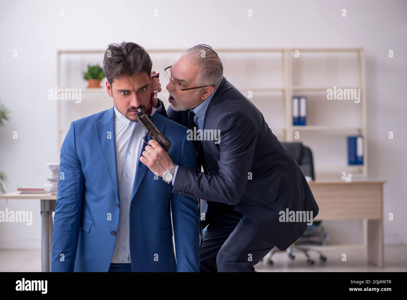 Old boss and young employee in bullying concept Stock Photo - Alamy