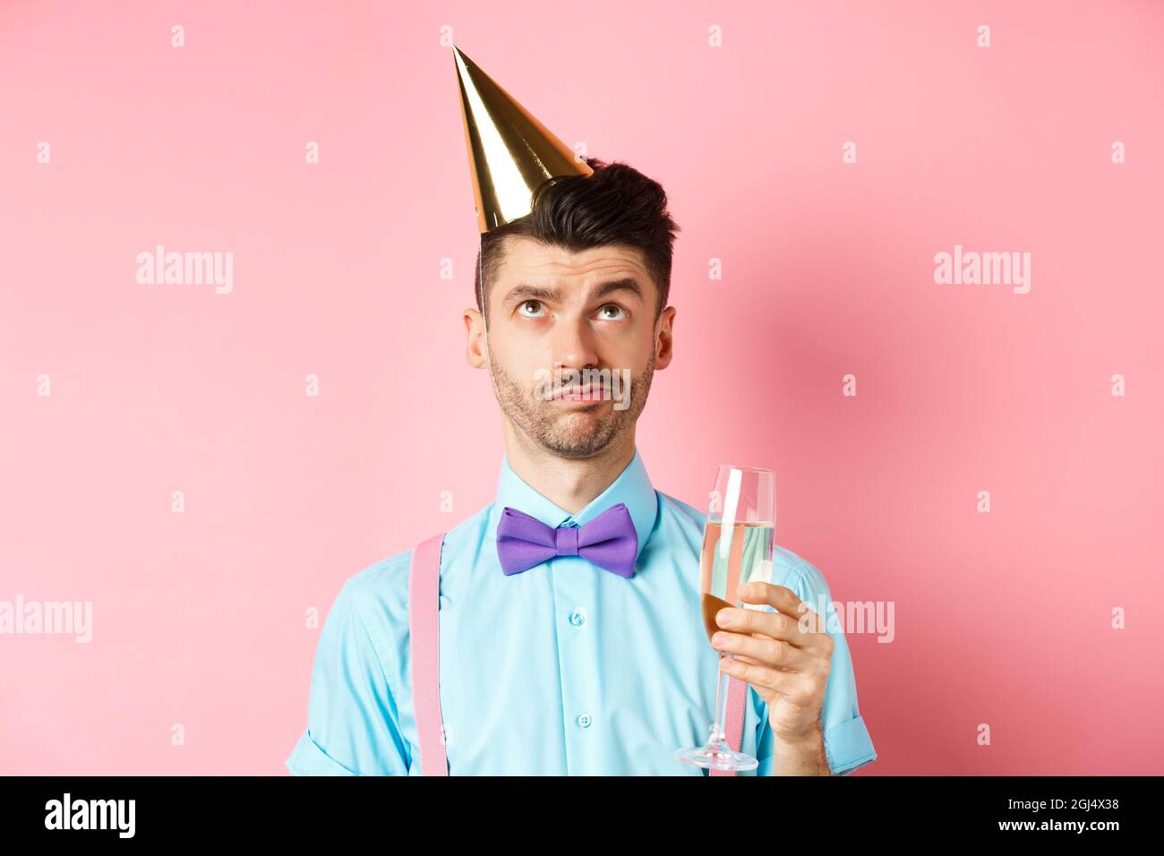 Holidays and celebration concept. Grumpy guy wearing birthday party hat ...