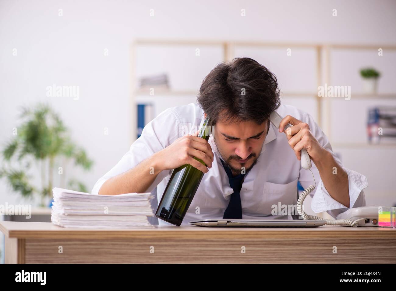 Male alcohol addicted employee sitting in the office Stock Photo - Alamy