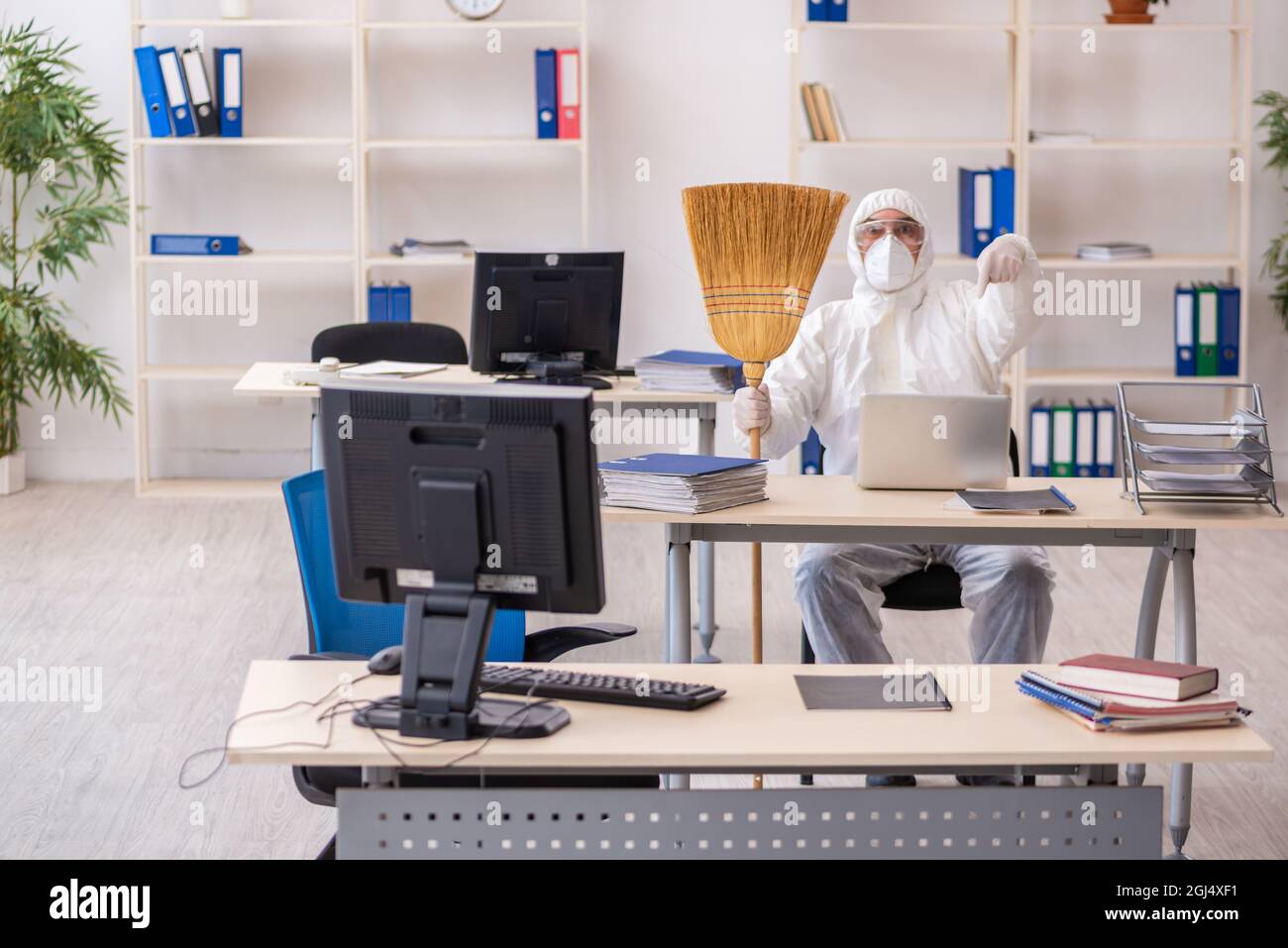 Old contractor cleaning the office holding broom Stock Photo - Alamy
