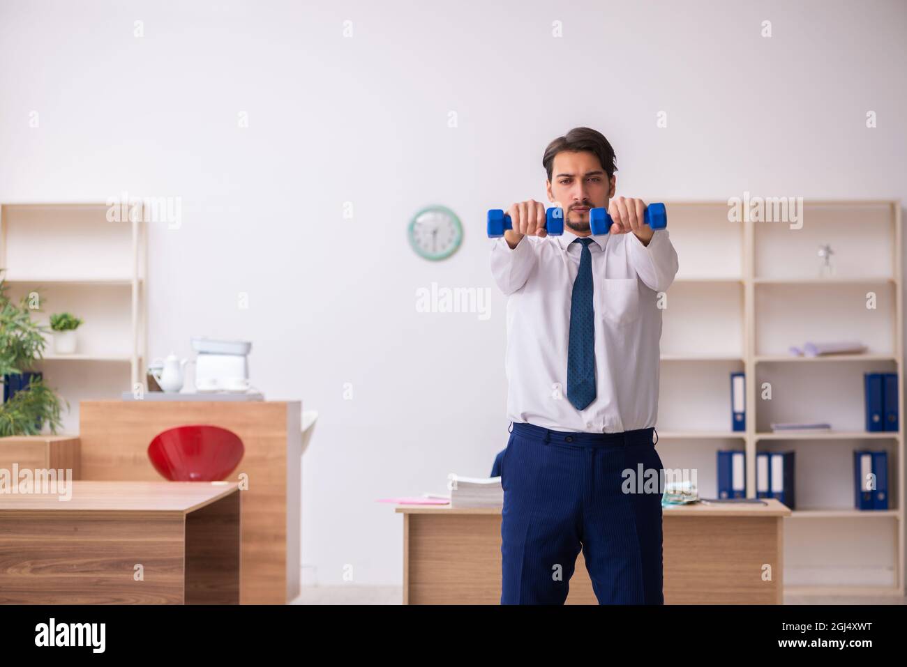 Young businessman employee doing sport exercises during break Stock ...