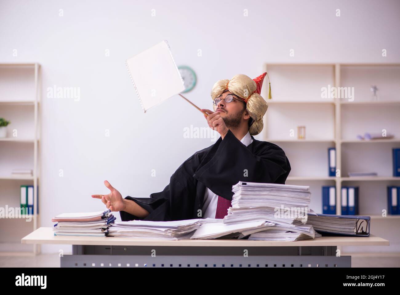 Funny young employee magician and too much work in the office Stock ...