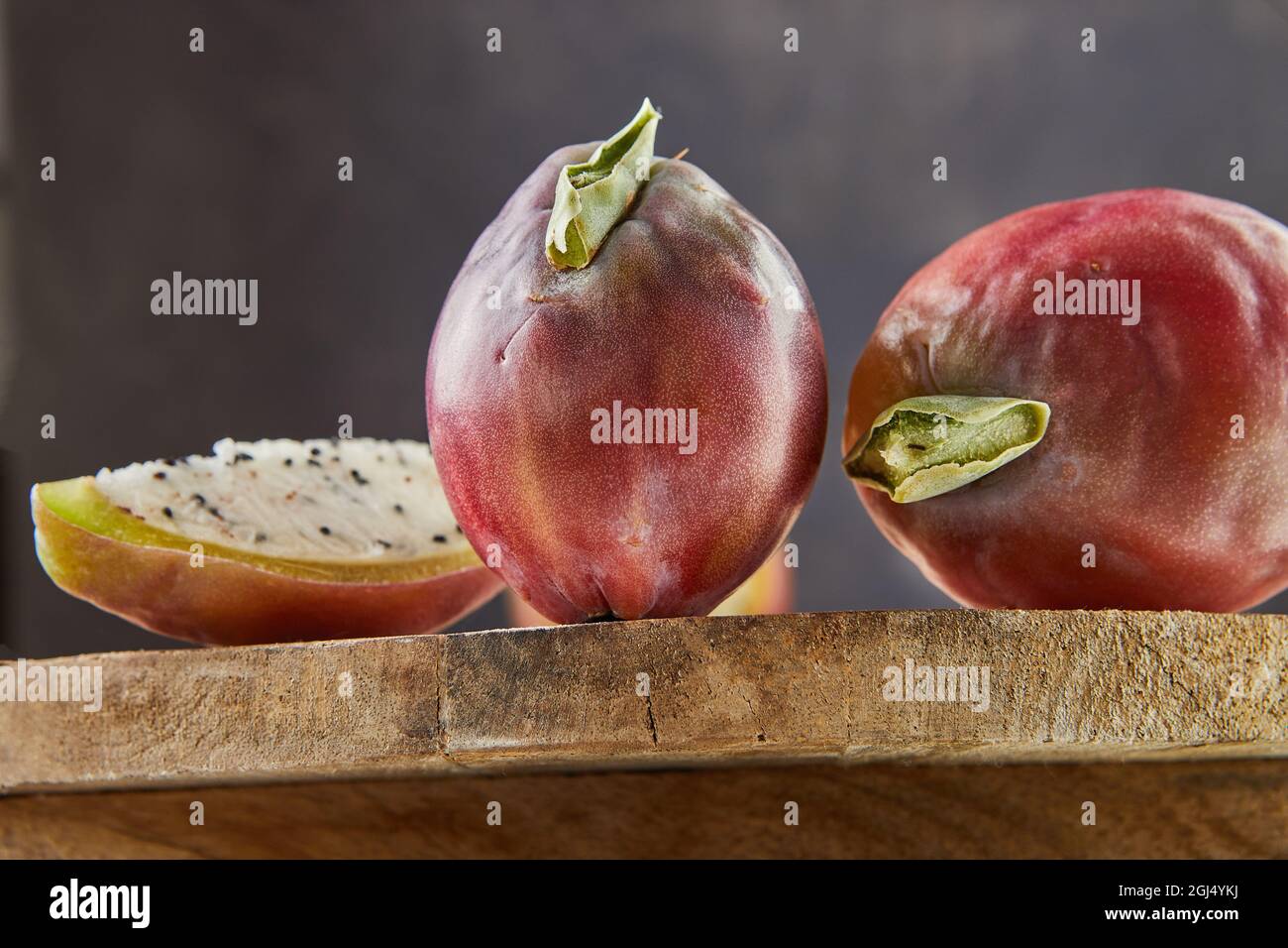 Peruvian apple cactus fruits whole and cut on wooden stand on gray ...