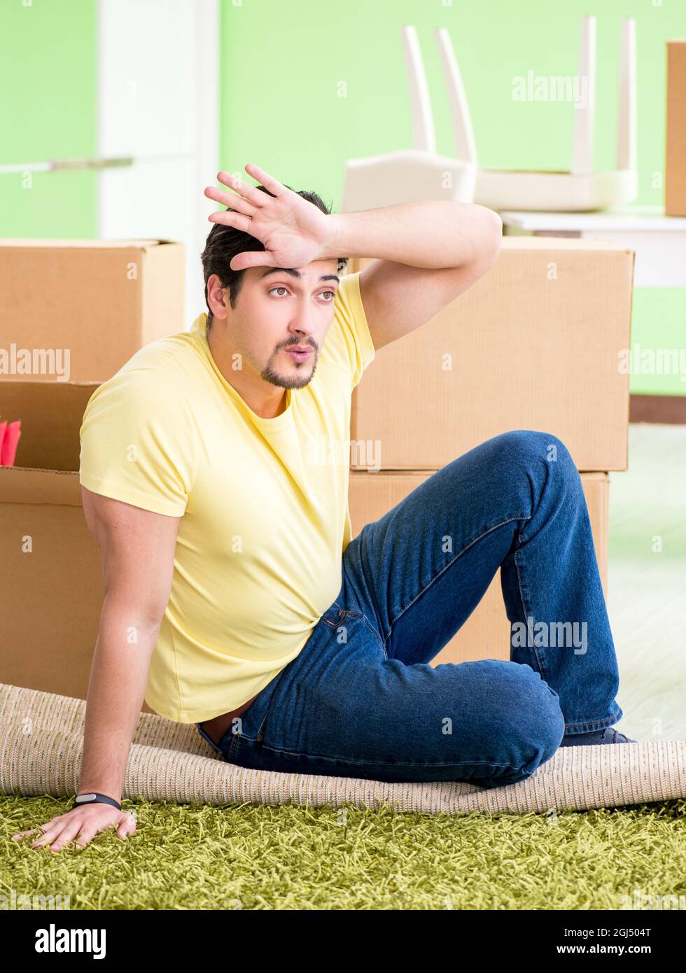 The young handsome man moving in to new house with boxes Stock Photo ...