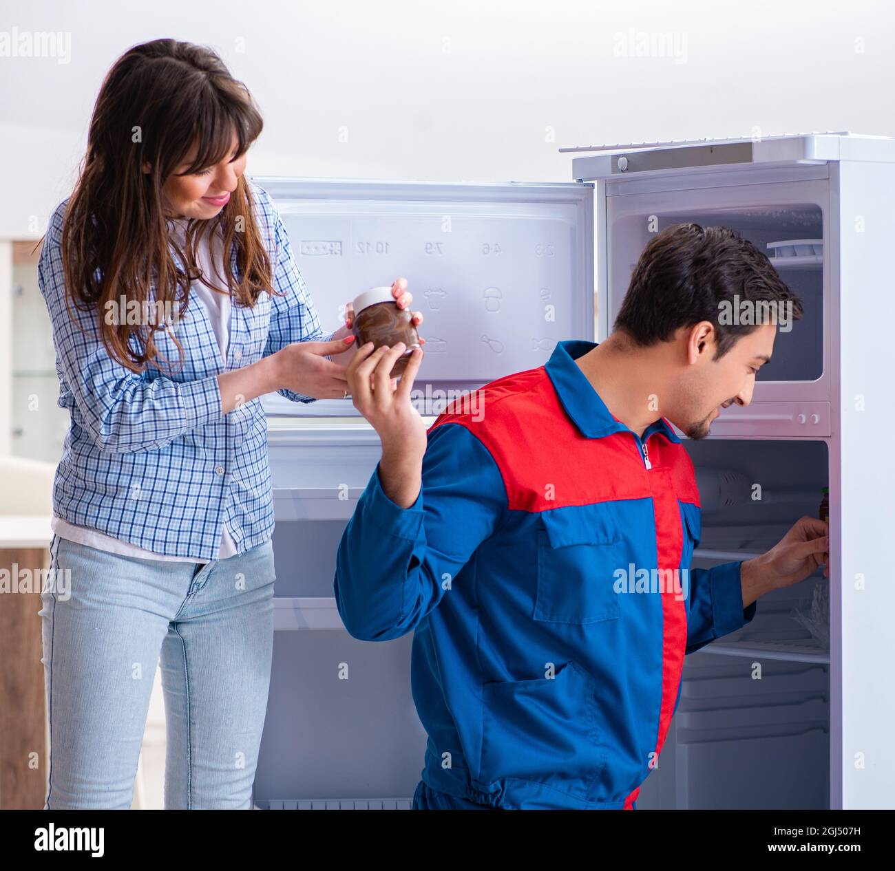 The man repairing fridge with customer Stock Photo - Alamy