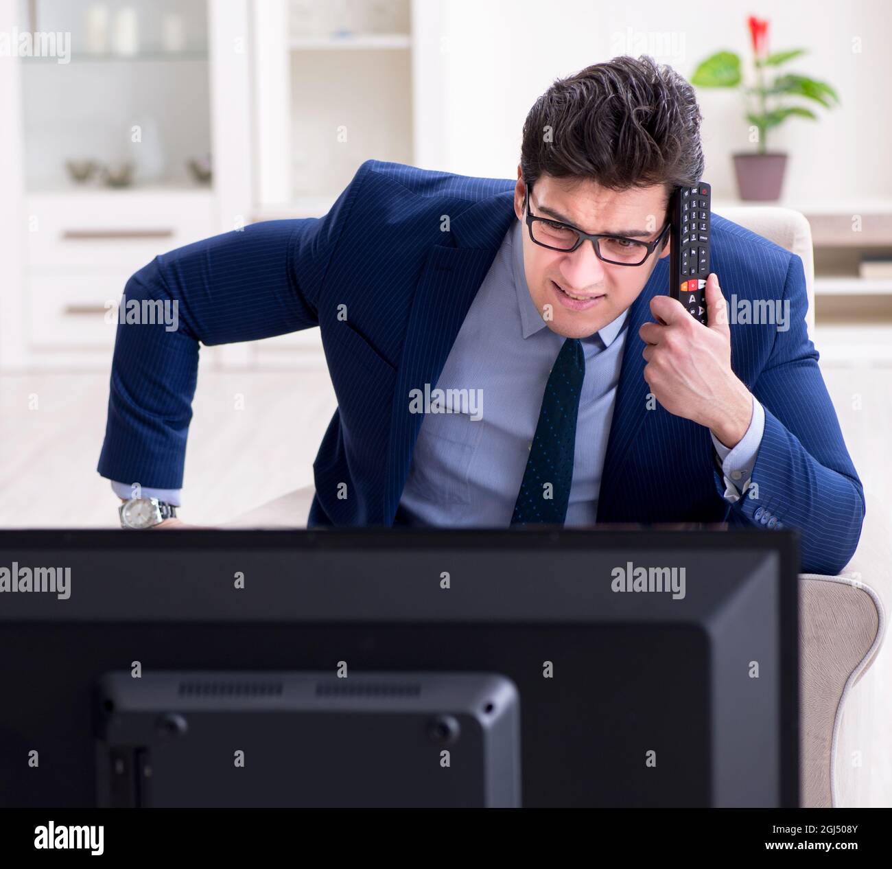 The businessman watching tv in the office Stock Photo - Alamy