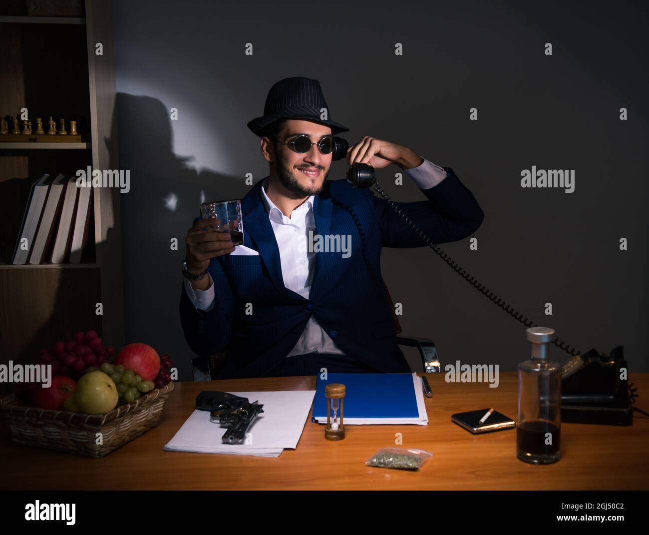 The detective sitting in dark room in vintage concept Stock Photo - Alamy