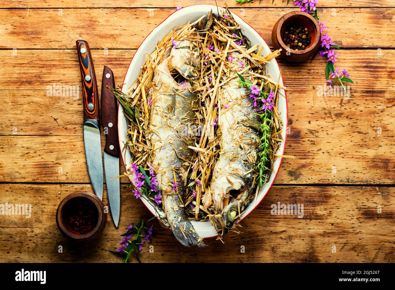 Fish baked in herbs and meadow hay. Roasted sea bass with spicy herbs ...