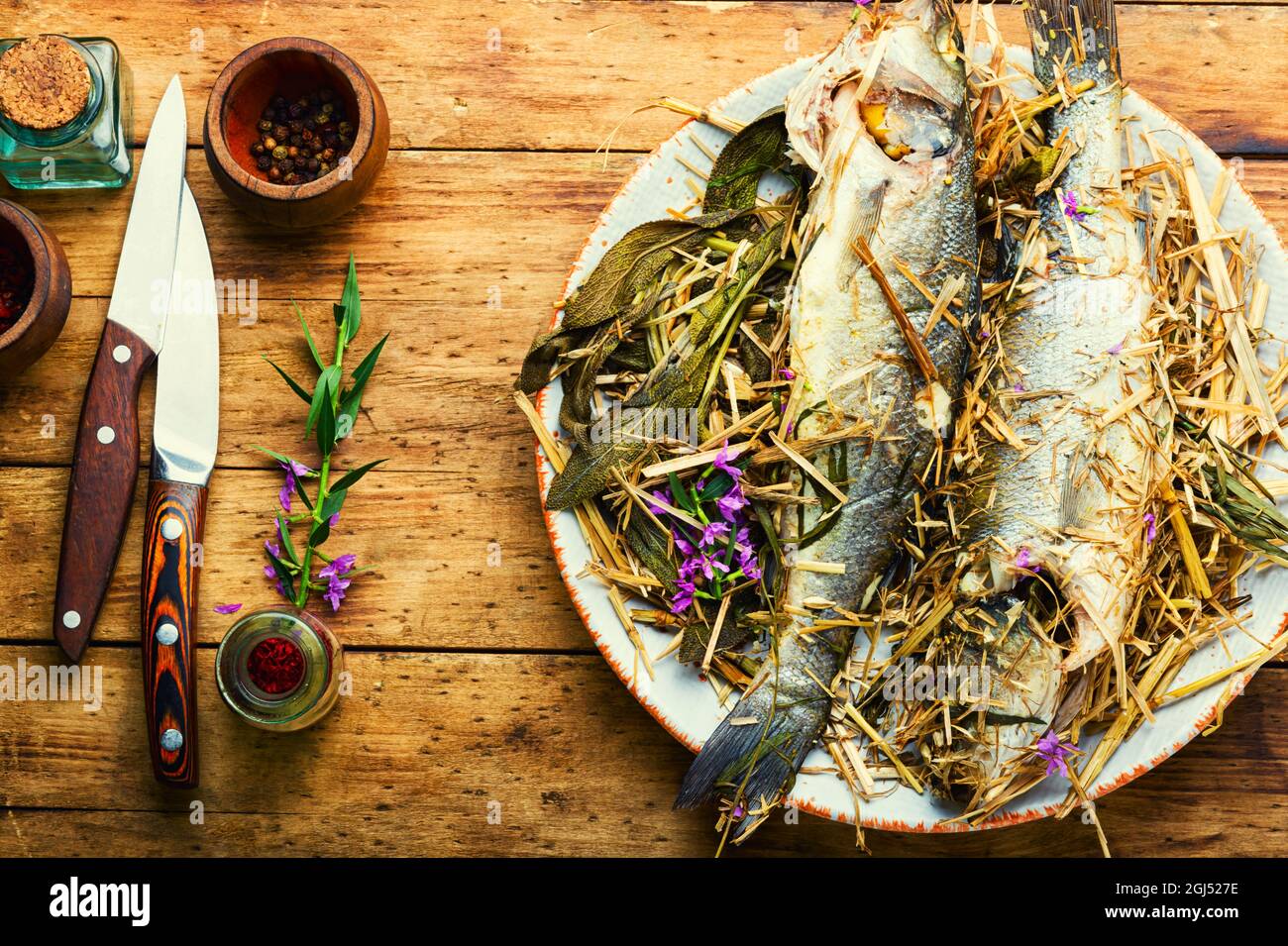 Fish baked in herbs and meadow hay. Roasted sea bass with spicy herbs ...