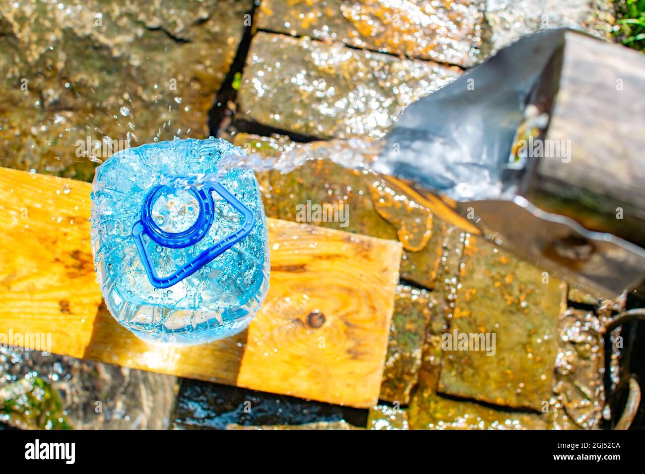 top view of the process of filling a plastic bottle with spring water ...