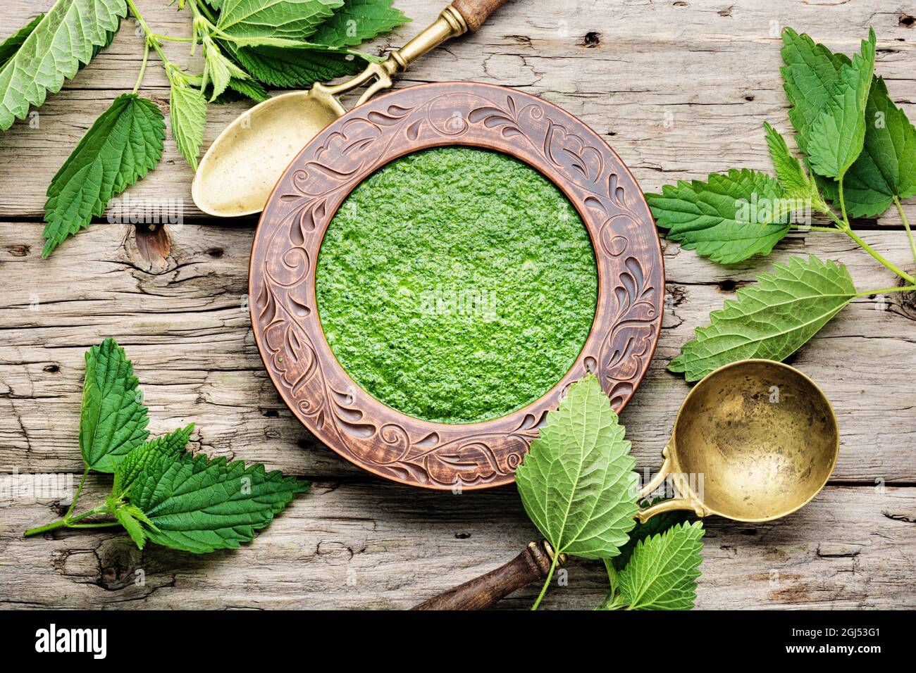 Summer green nettle soup.Fresh nettle.Cream soup on wooden table ...