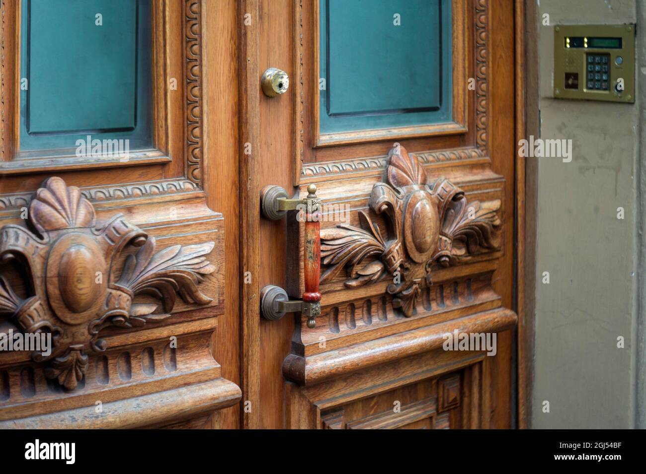 high resolution image of a massive carved wooden door with intercom ...